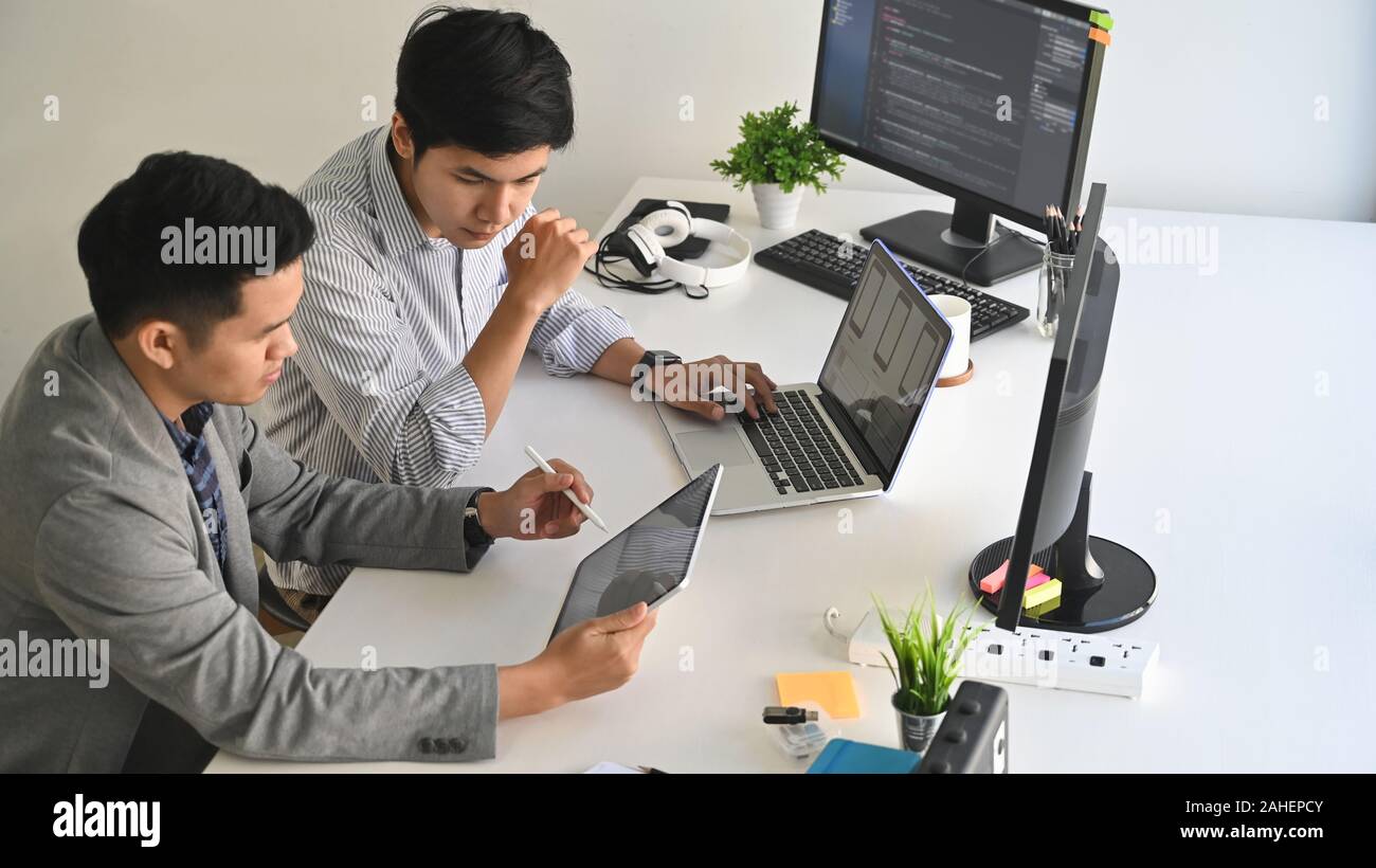 A two male programer working with laptop and coding on computer Stock ...