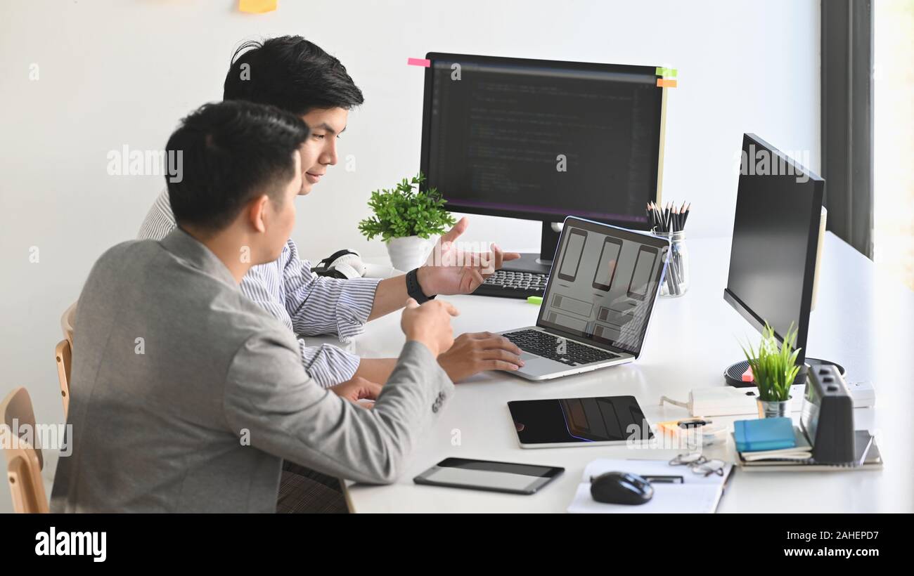 A two male programer working with laptop and coding on computer Stock Photo - Alamy