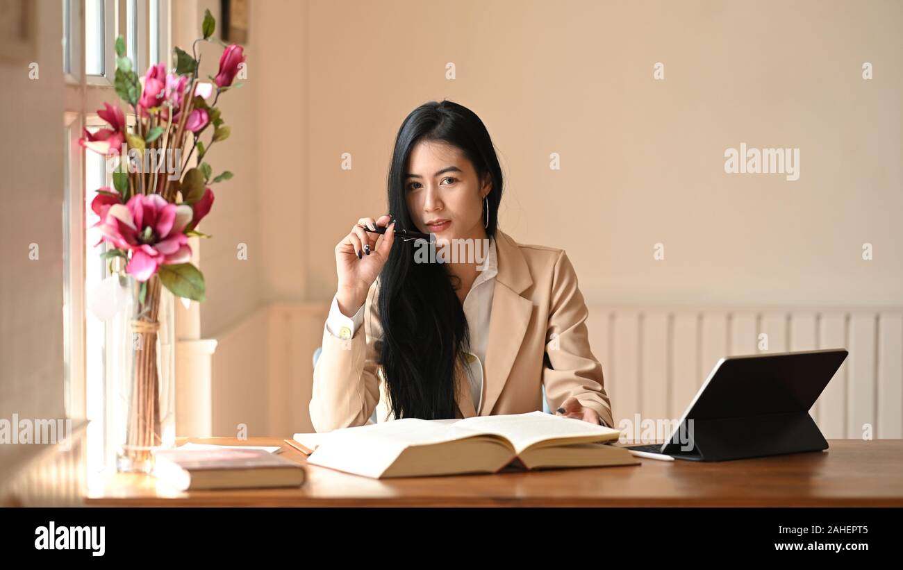 Portrait female editor book on office workspace Stock Photo - Alamy