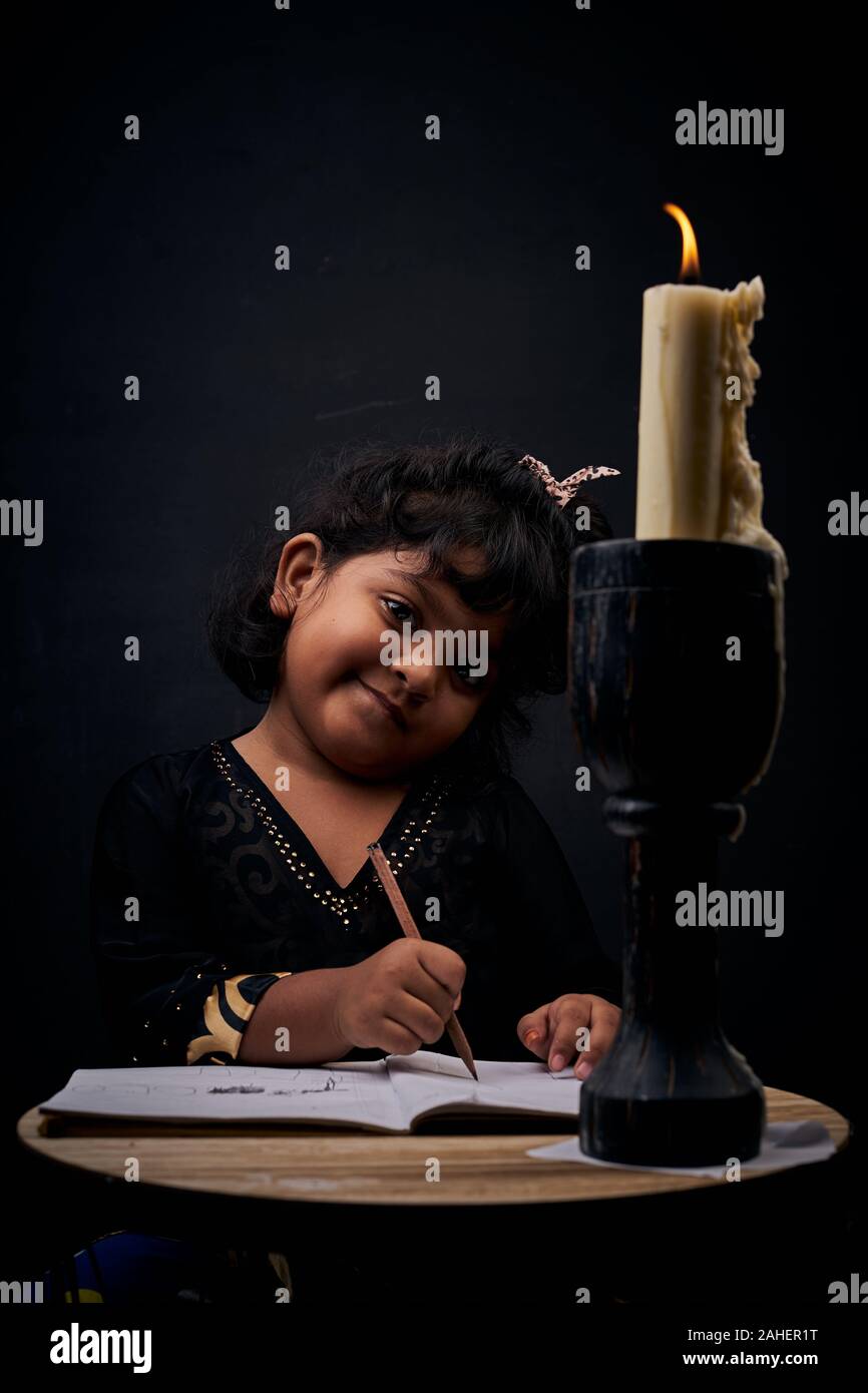 Little Girl writing homework in Candle light at night Stock Photo - Alamy