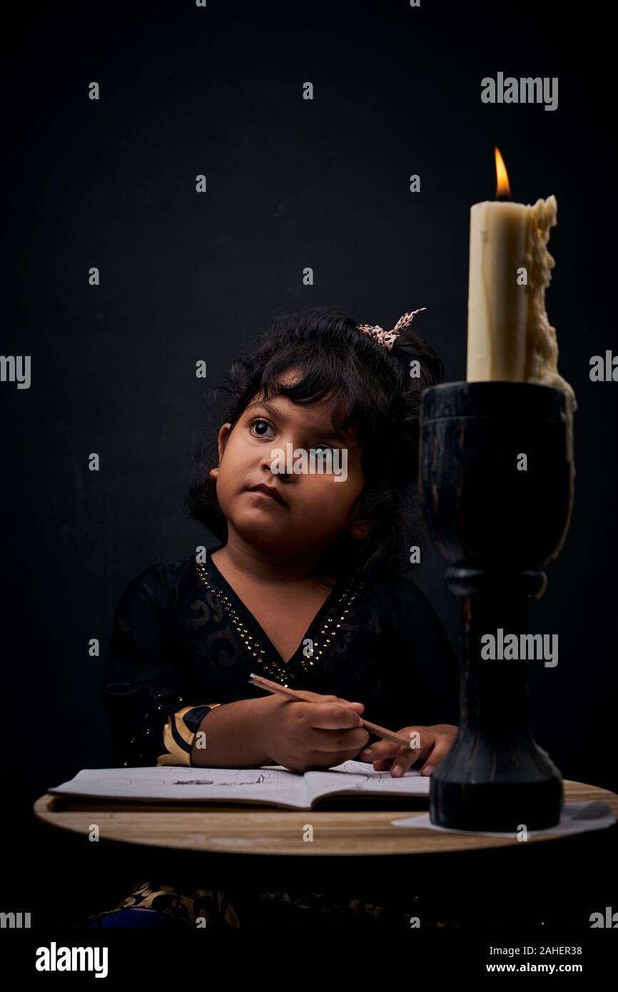 Little Girl writing homework in Candle light at night Stock Photo - Alamy