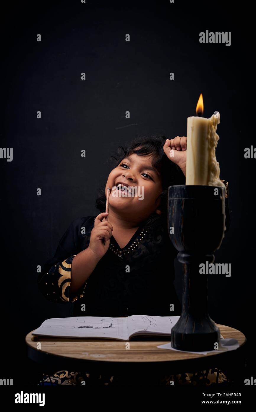 Little Girl writing homework in Candle light at night Stock Photo - Alamy
