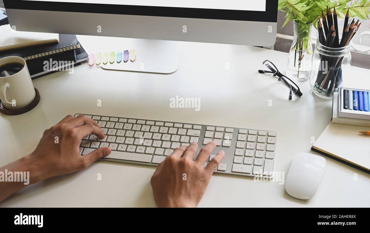 Top view man's hands using computer on home office with cropped shot ...