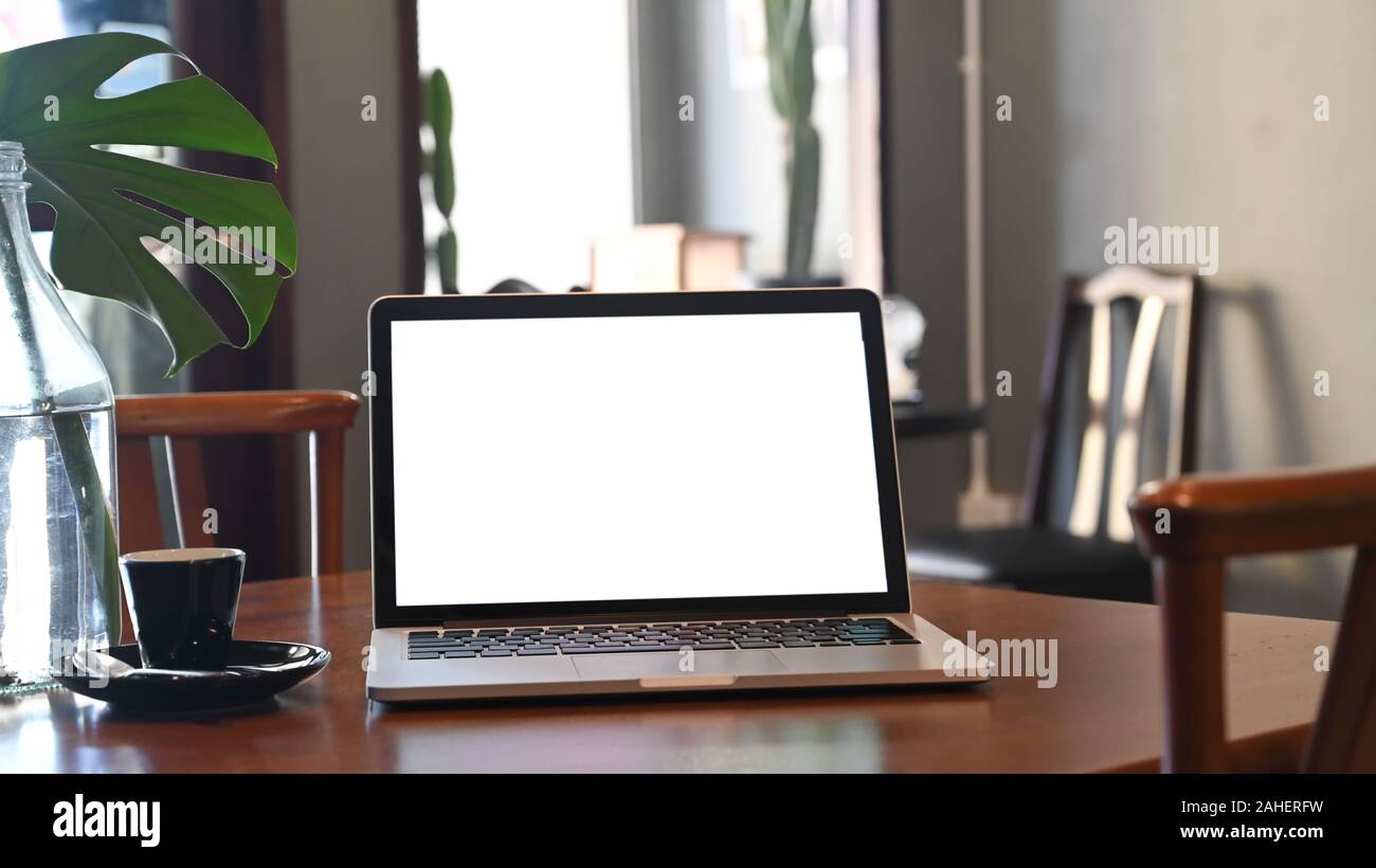 Mockup laptop computer on wooden cafe Stock Photo - Alamy