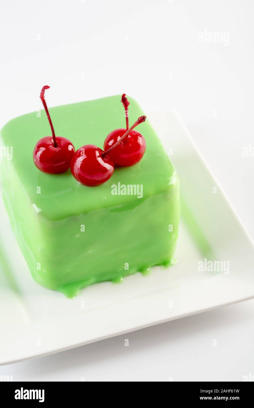 Green mousse cake with chery on plate Stock Photo - Alamy