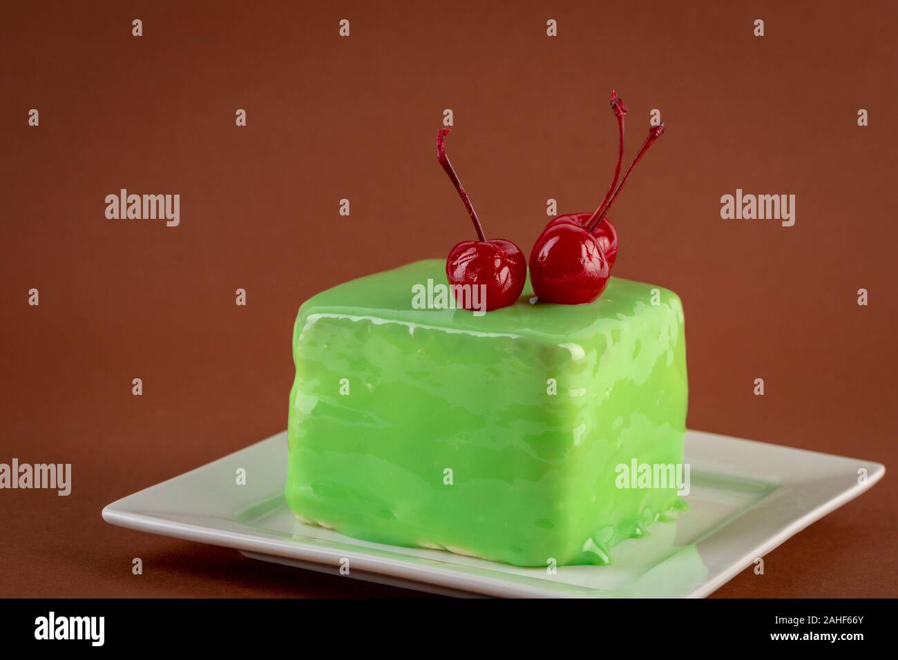 Green mousse cake with chery, brown background Stock Photo - Alamy