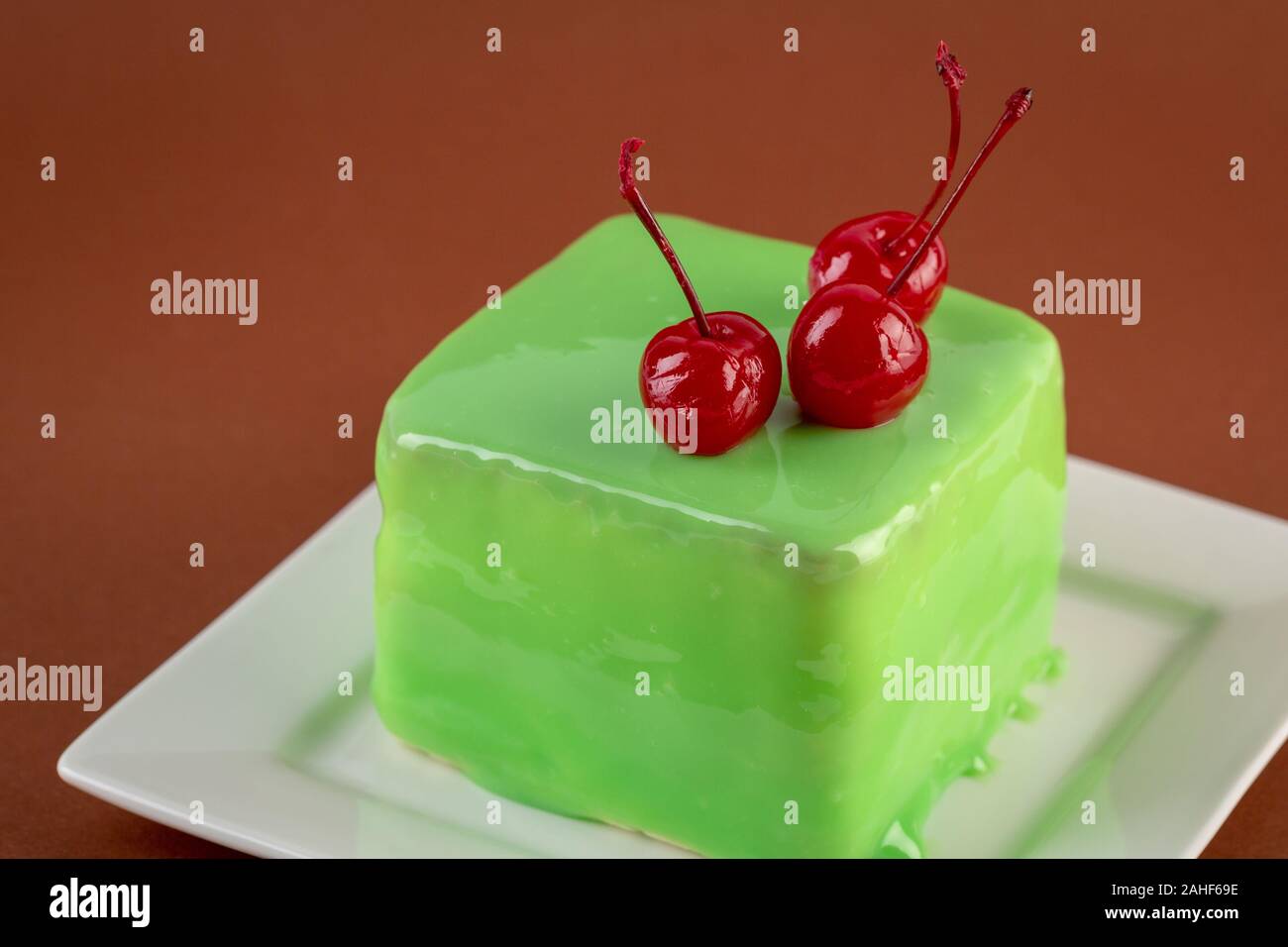 Sweet green mousse cake with chery, brown background Stock Photo - Alamy
