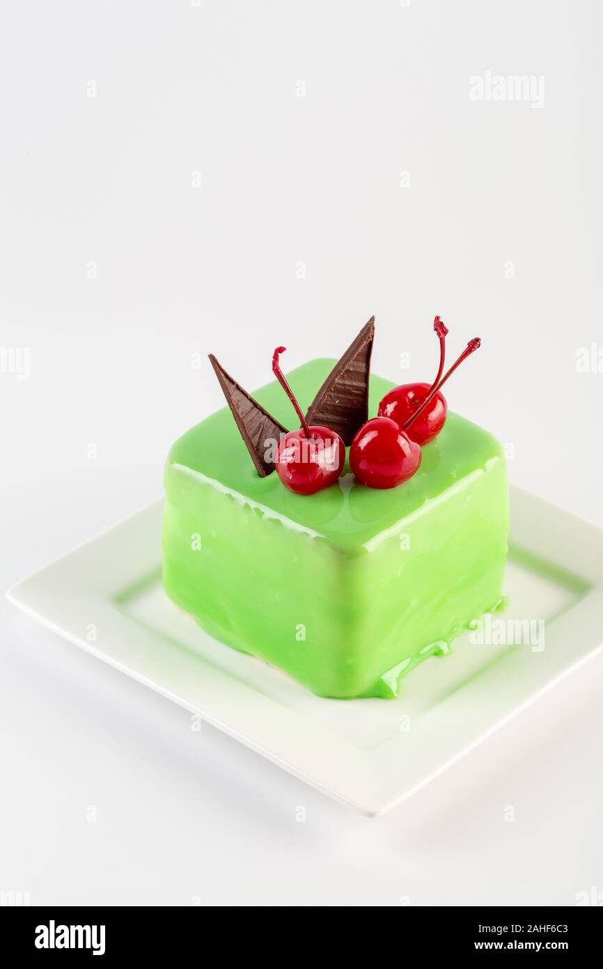 Sweet green mousse cake with chery on top Stock Photo - Alamy