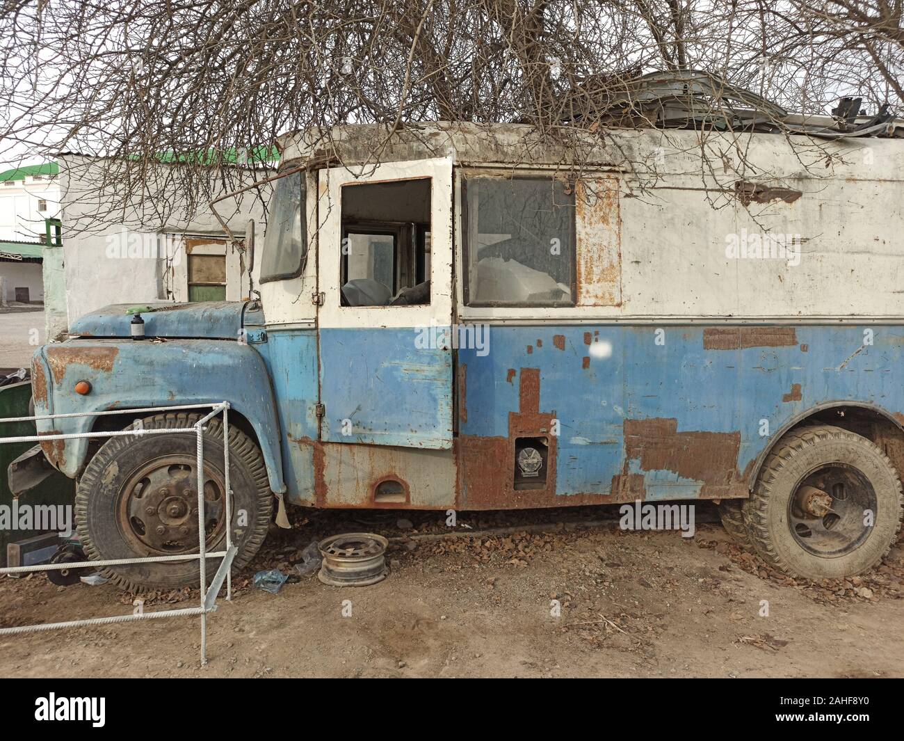 an old two-tone abandoned bus covered in rust Stock Photo - Alamy