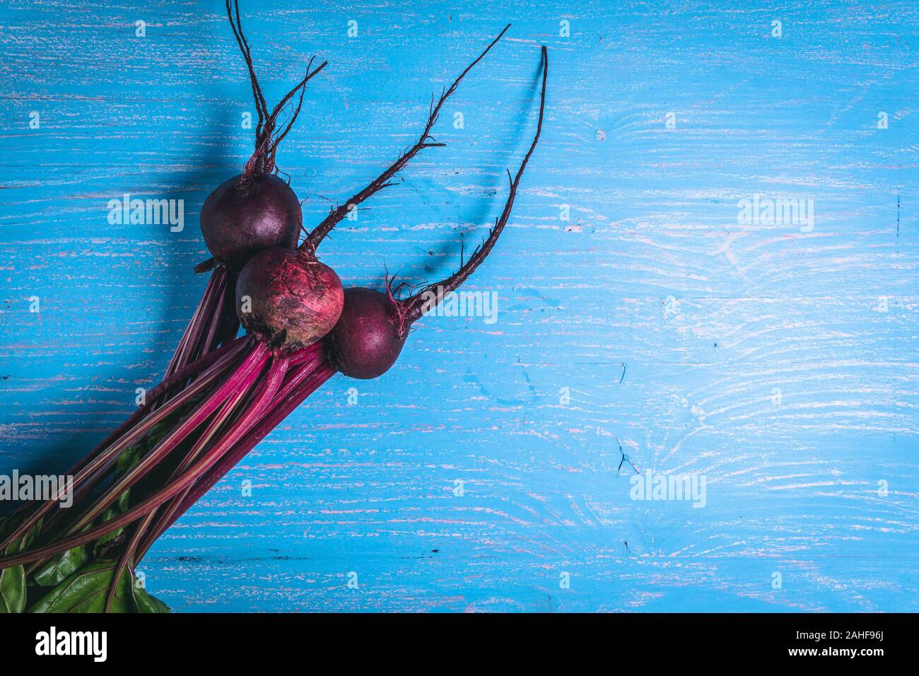 A bunch of fresh beets on old blue wooden table. Copy space. Healthy ...