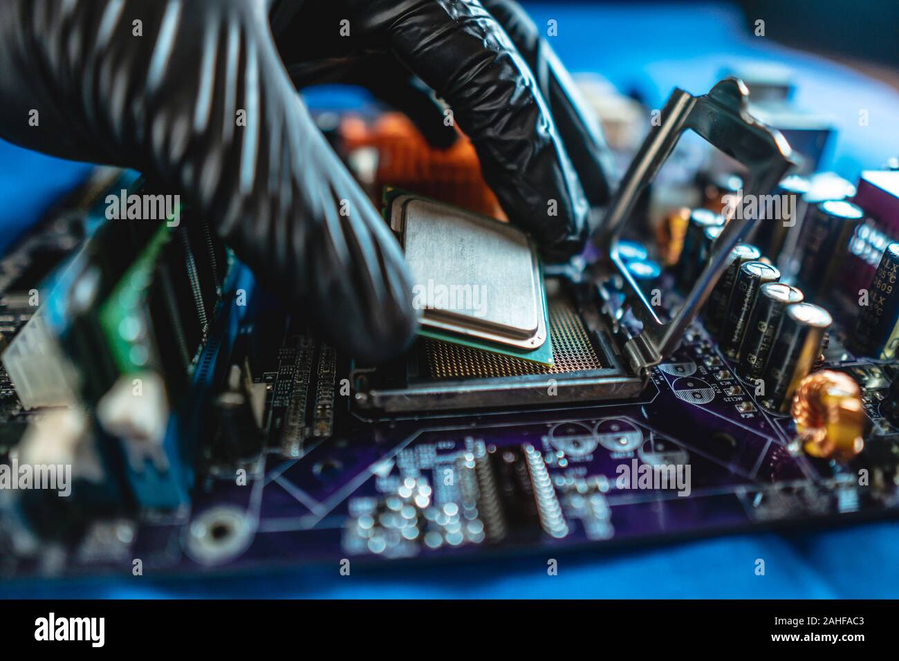 Engineer repairman holding hands in black gloves chip processor, CPU to insert into the socket ...