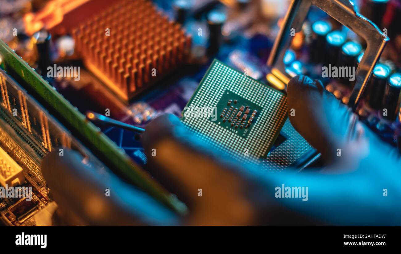 Engineer repairman holding hands in black gloves chip processor, CPU to insert into the socket ...