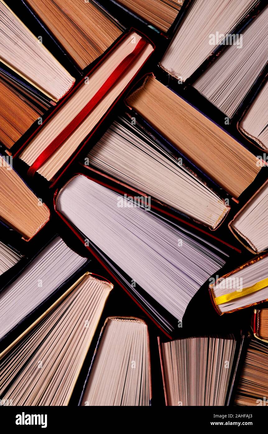 Books. Lots of colourful thick open books stand on a dark background ...