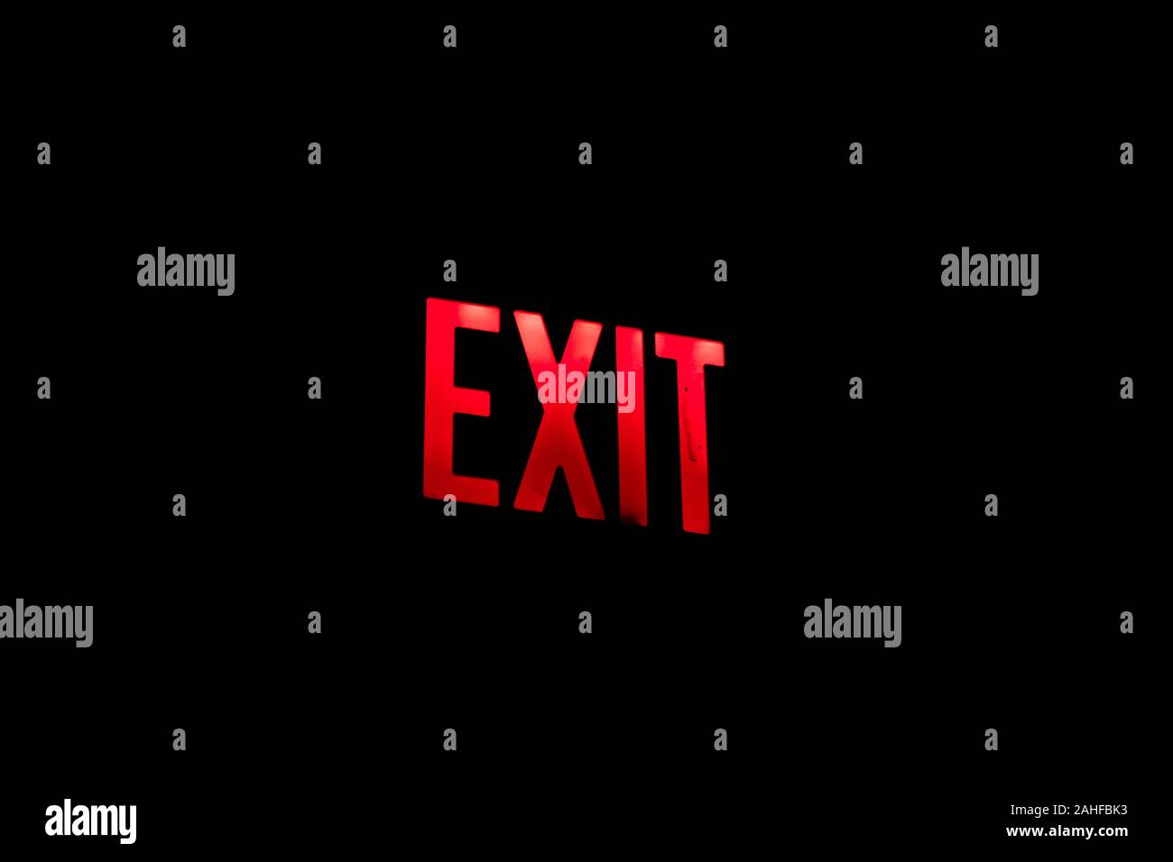 Bright red emergency exit sign on black background Stock Photo - Alamy
