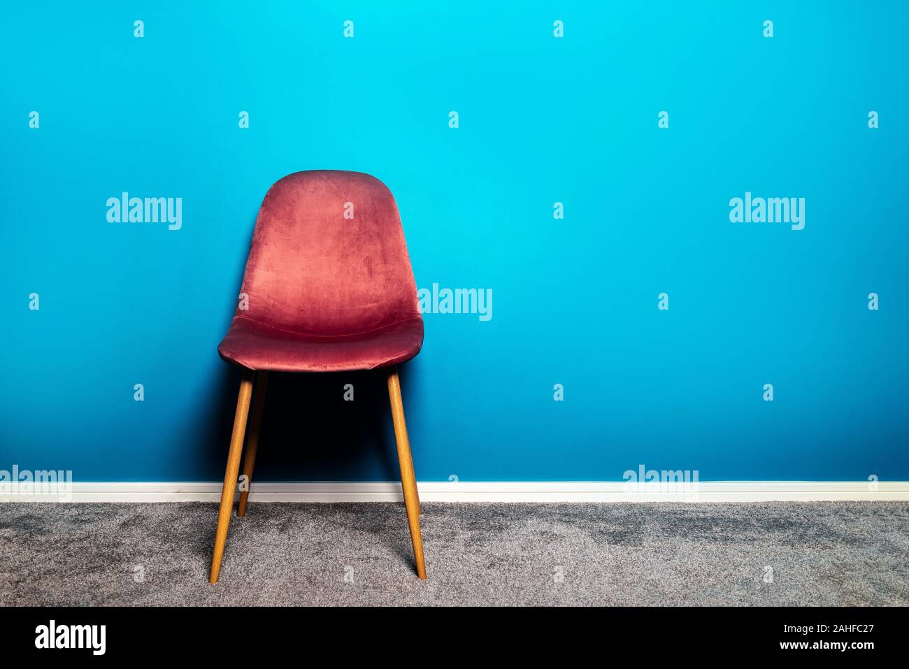 Modern Pink Velour Chair on wooden legs, blue background Stock Photo ...