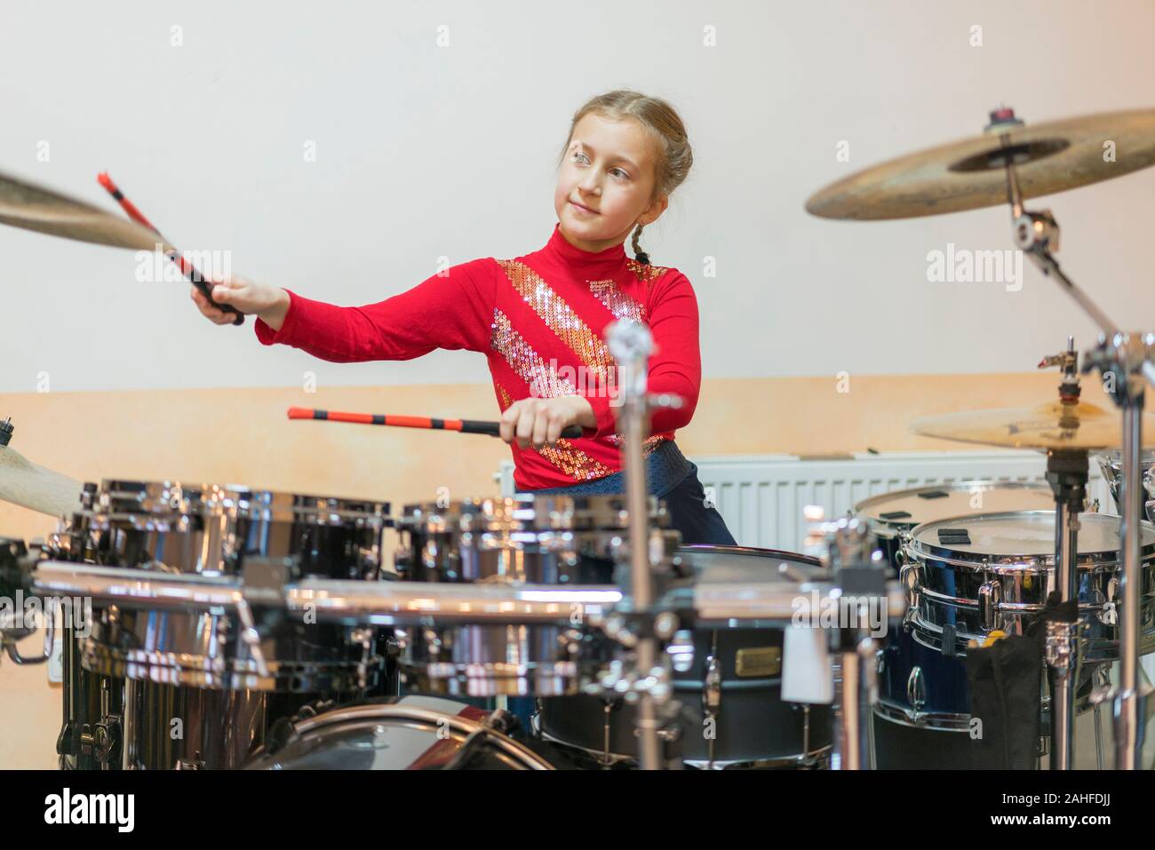 Teen girl playing the drums. Teen girls are having fun playing drum ...