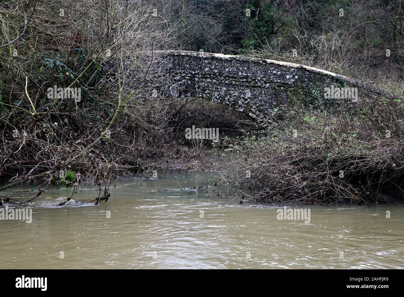 Forgotten old stone flint bridge over the River Mole seen along the ...