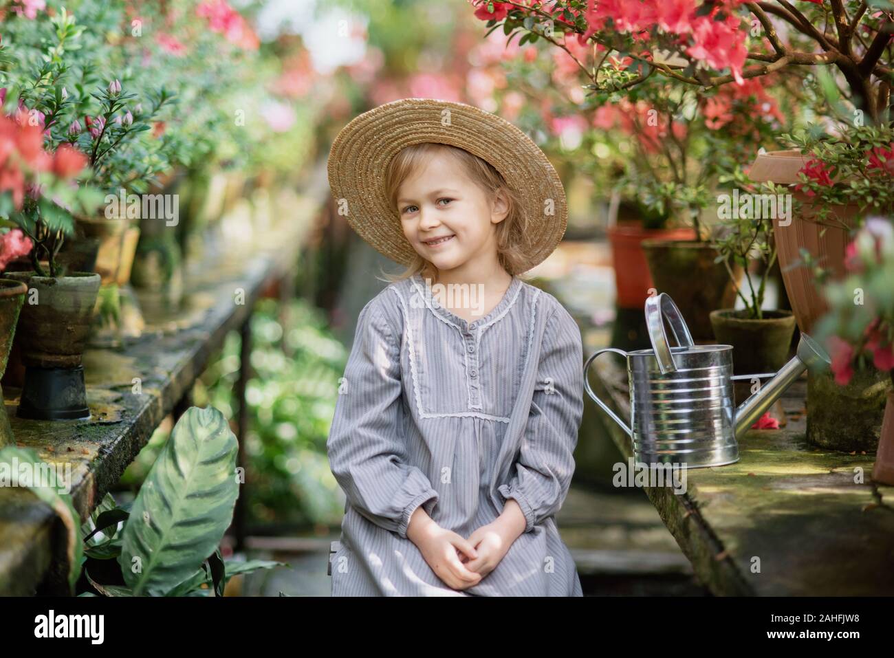 Child planting spring flowers. Little girl gardener plants azalea. Girl ...