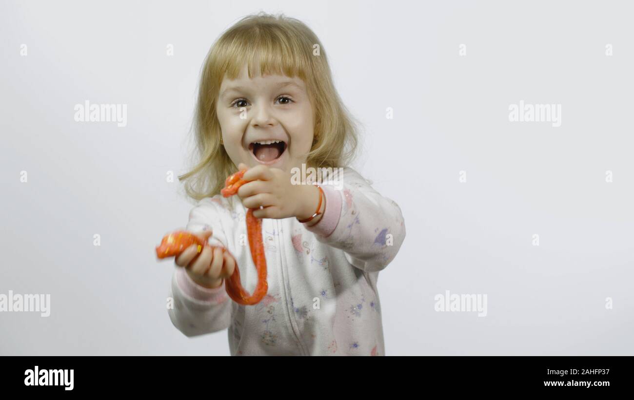 Child having fun making orange slime. Kid playing with hand made toy ...