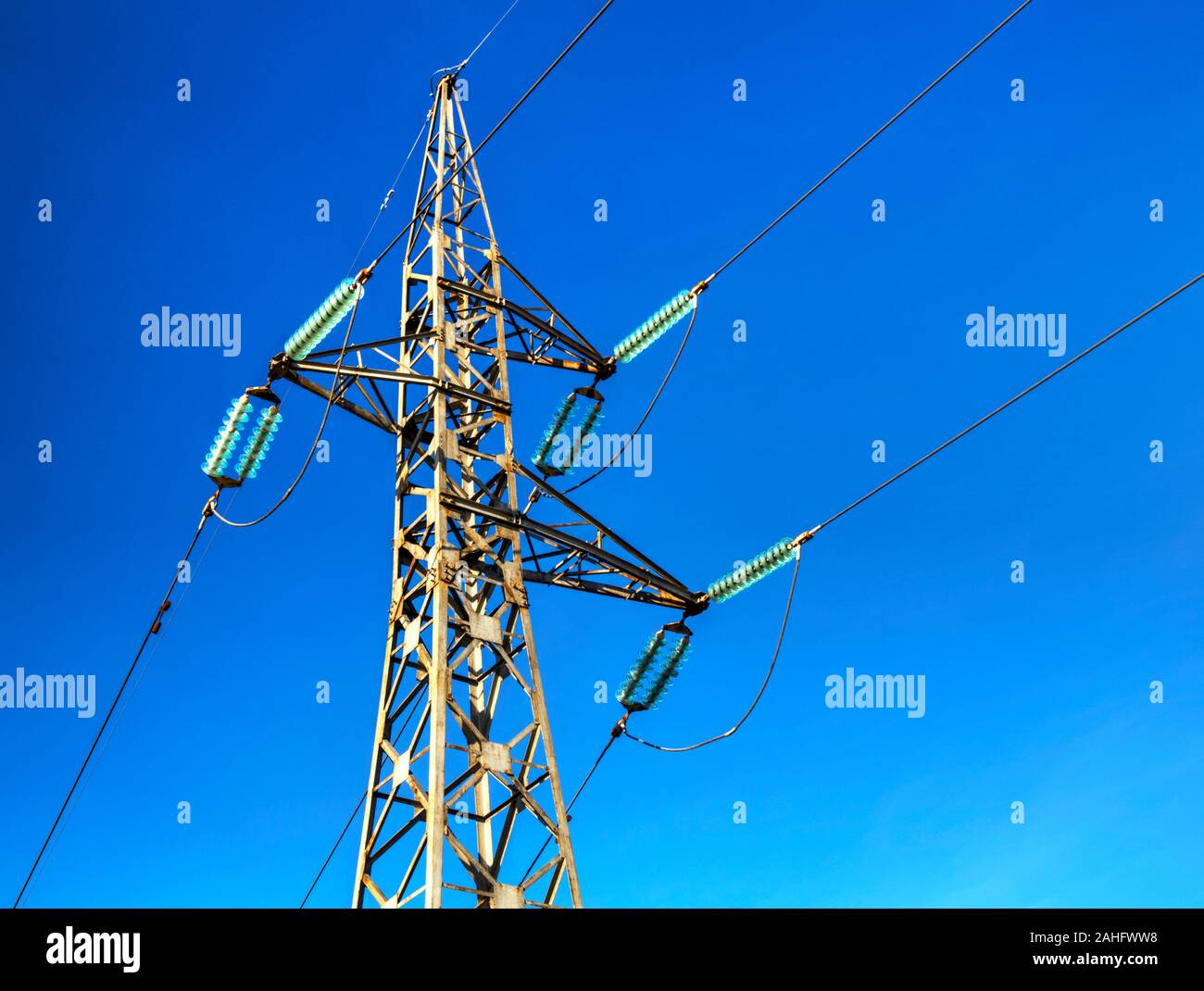 A pylon of overhead power line on blue sky Stock Photo - Alamy