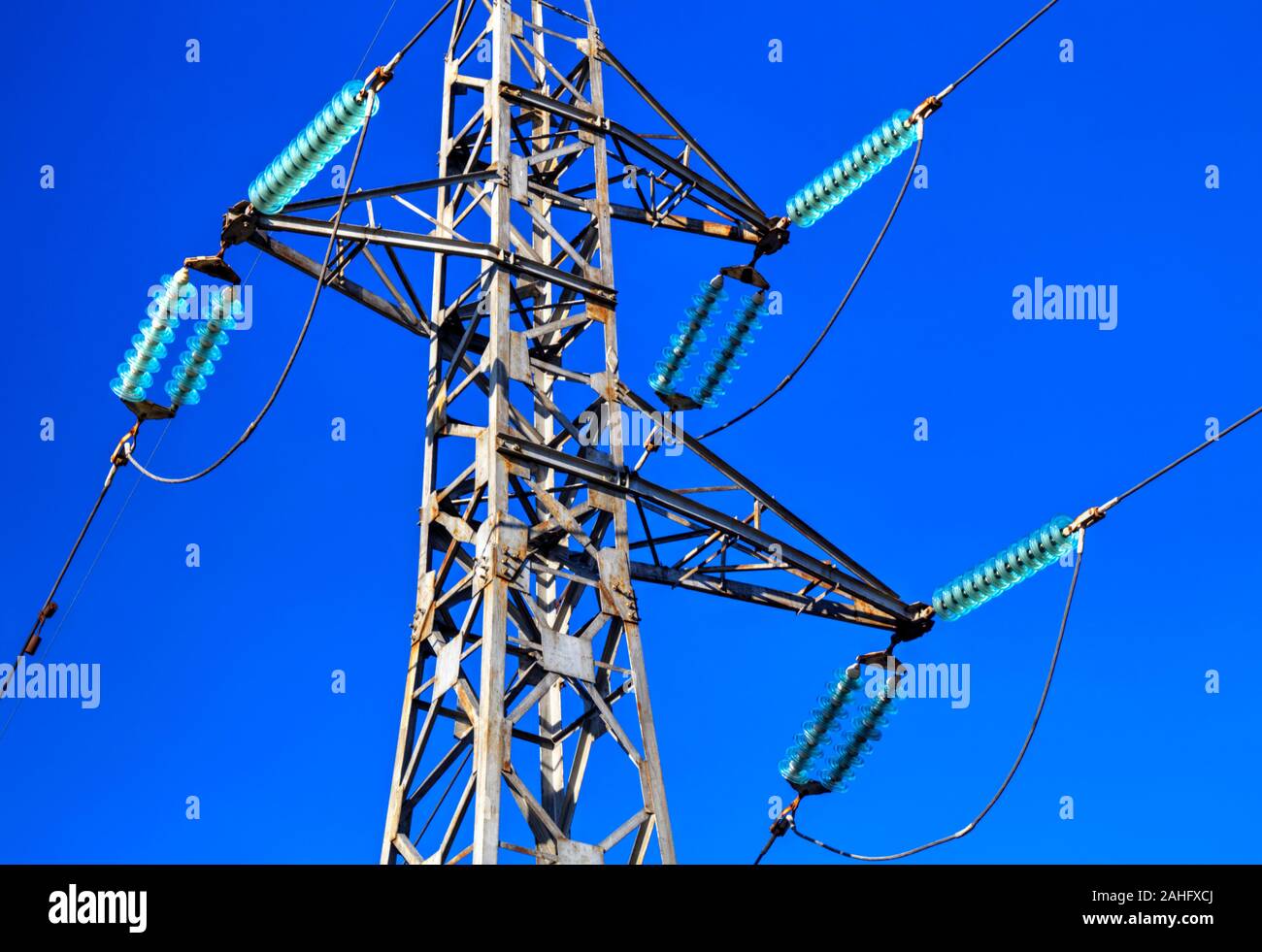 A pylon of overhead power line on blue sky Stock Photo - Alamy