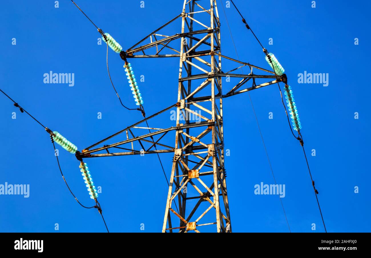 A pylon of overhead power line on blue sky Stock Photo - Alamy