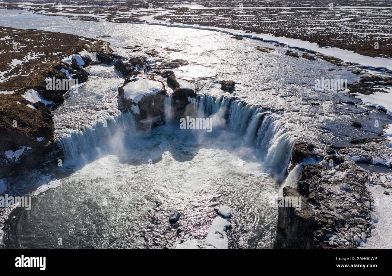 Aerial view of Godafoss waterfall, snowy shore and river. Iceland in ...