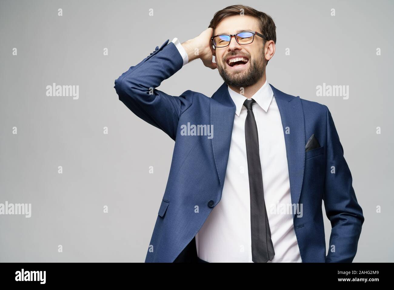 Very happy successful winner gesturing businessman over grey background ...