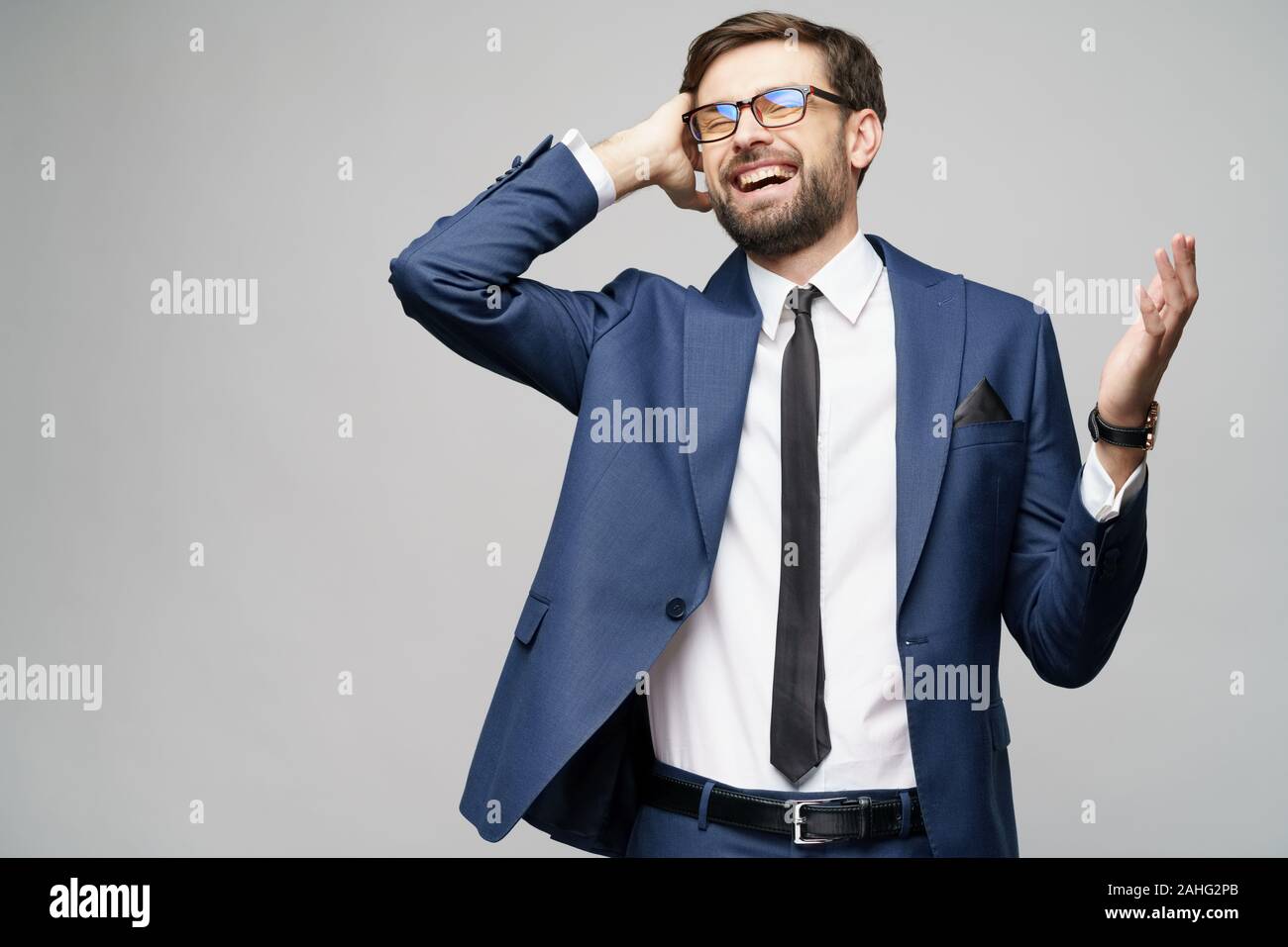 Very happy successful winner gesturing businessman over grey background ...