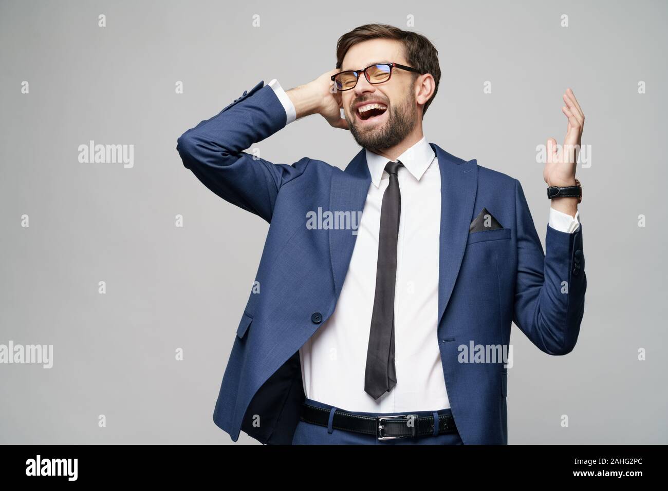 Very happy successful winner gesturing businessman over grey background ...