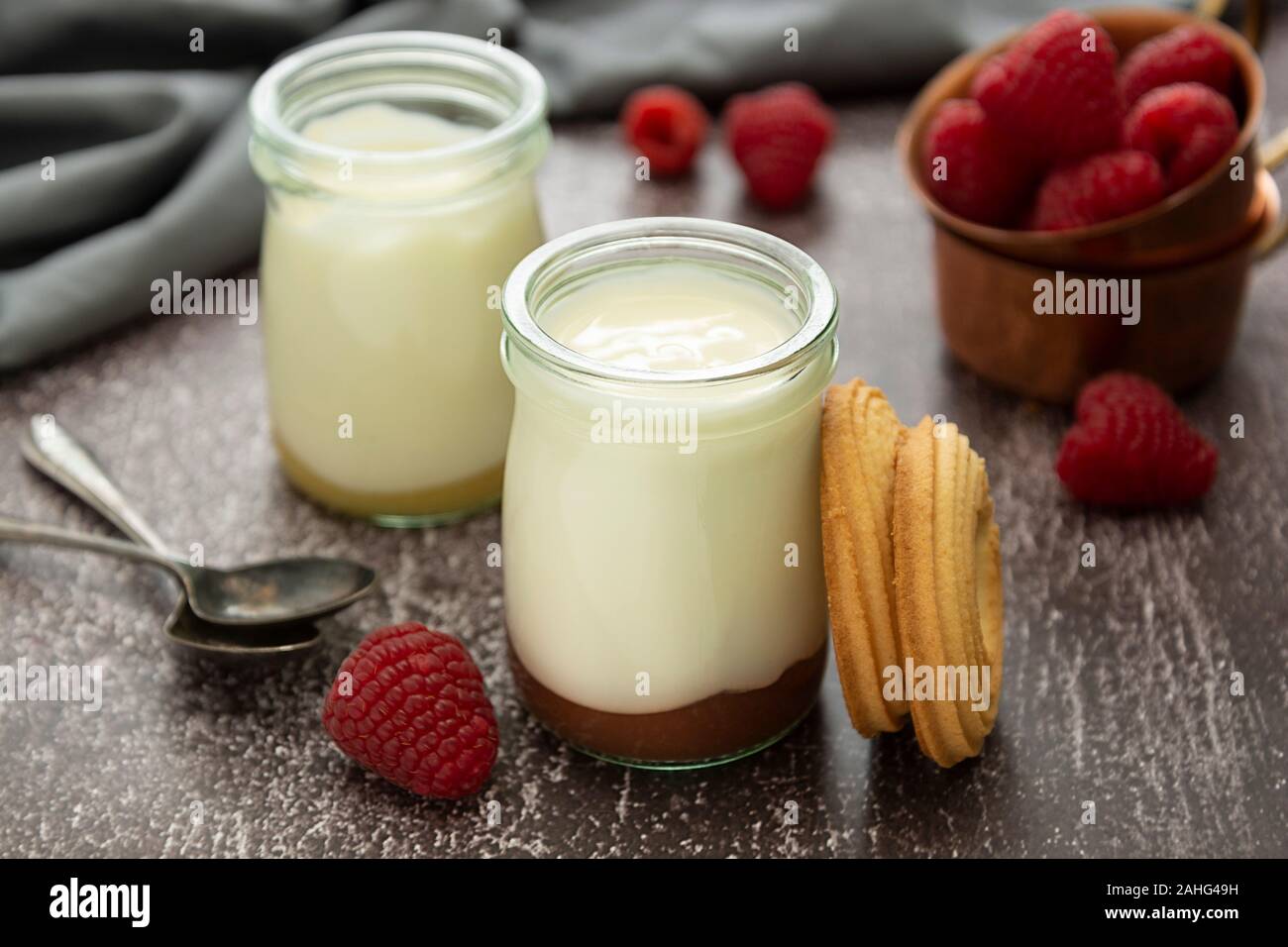 Fresh yogurt in glass jar with berry fruits on dark background. Healthy ...