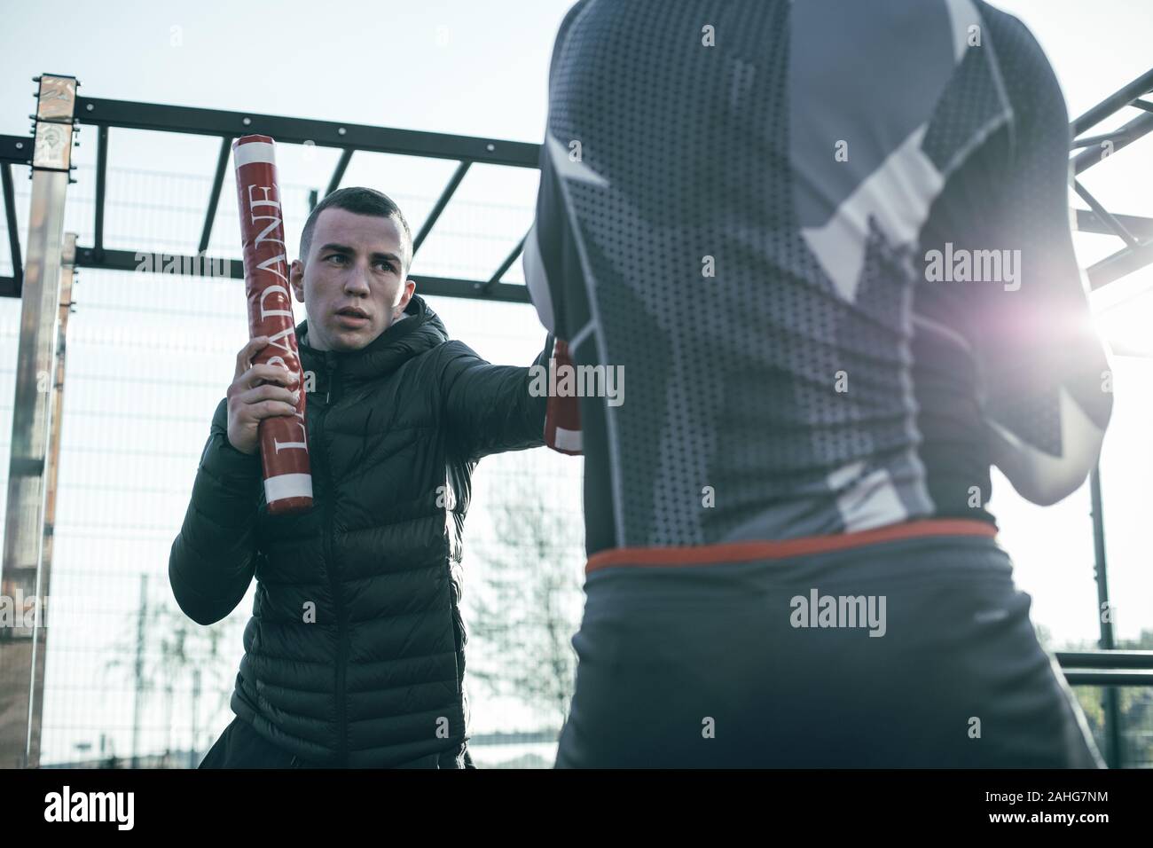 Confident man holding boxing sticks and conducting the boxing training ...