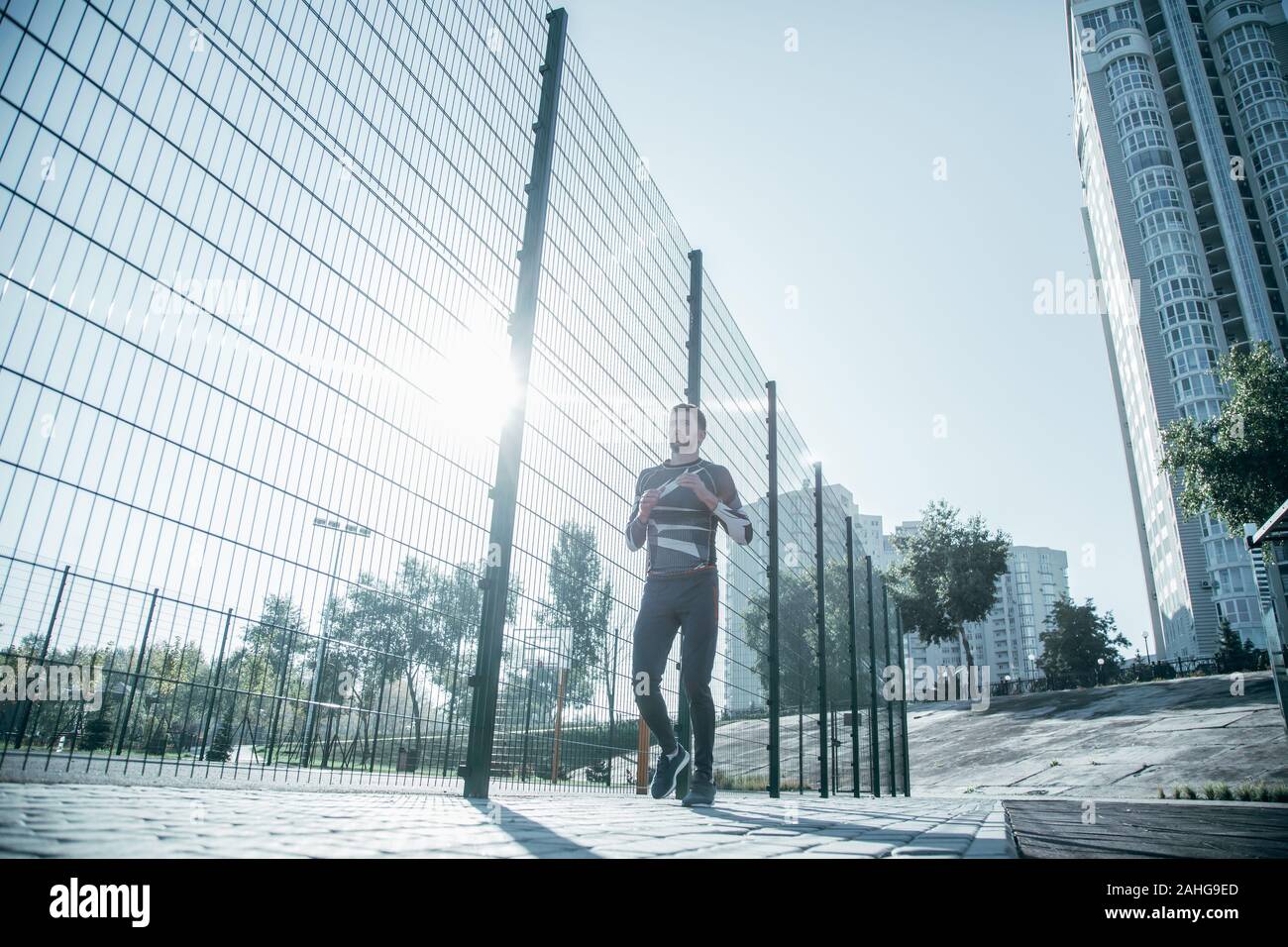 Young sportsman looking serious while running at the sports ground ...