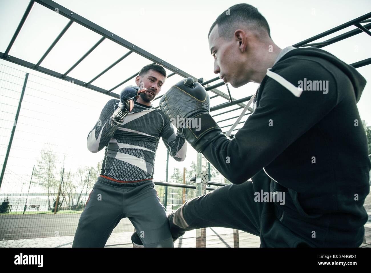 Two boxers looking serious while fighting outdoors at the training ...