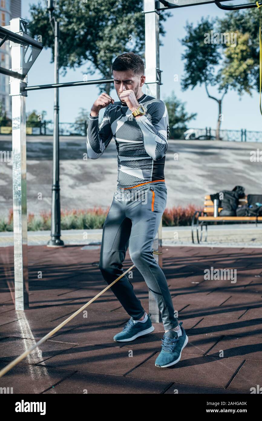 Serious sportsman jumping over the rope while having his training Stock ...