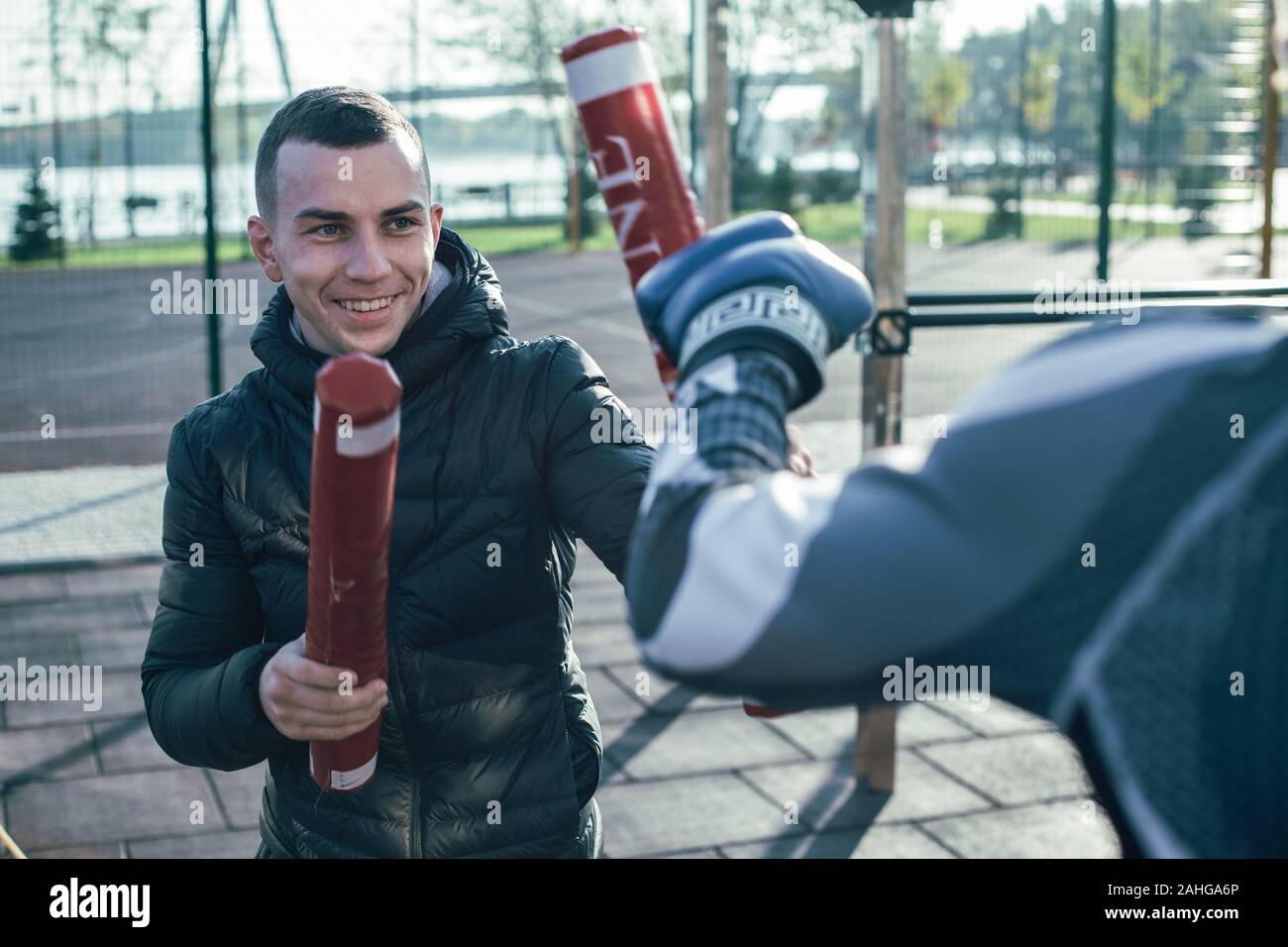 Optimistic trainer smiling while having training with his boxer Stock ...