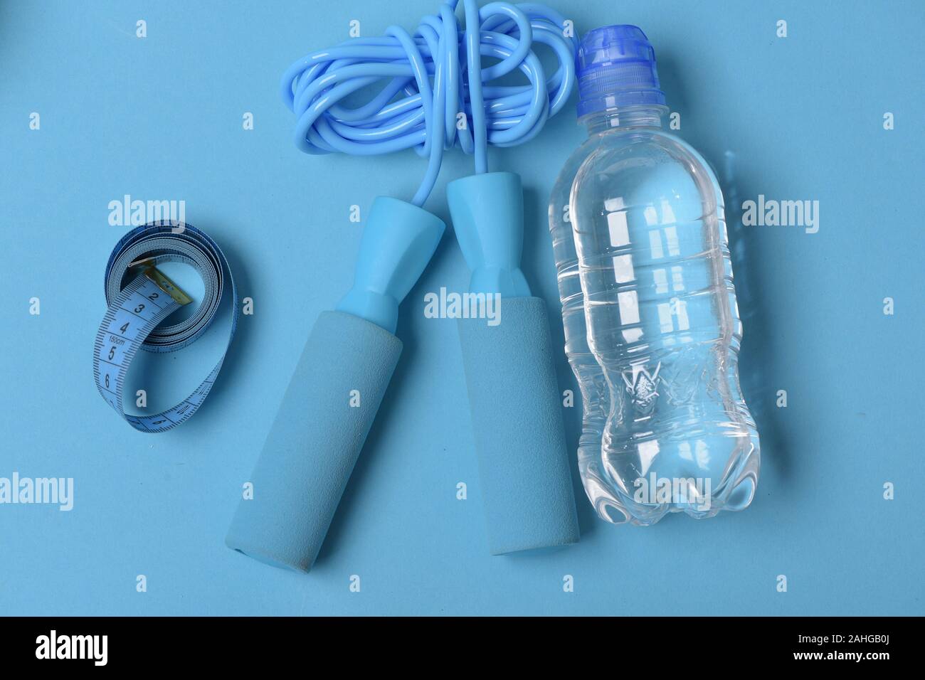 Skipping rope in cyan color on blue background, top view. Jump rope ...