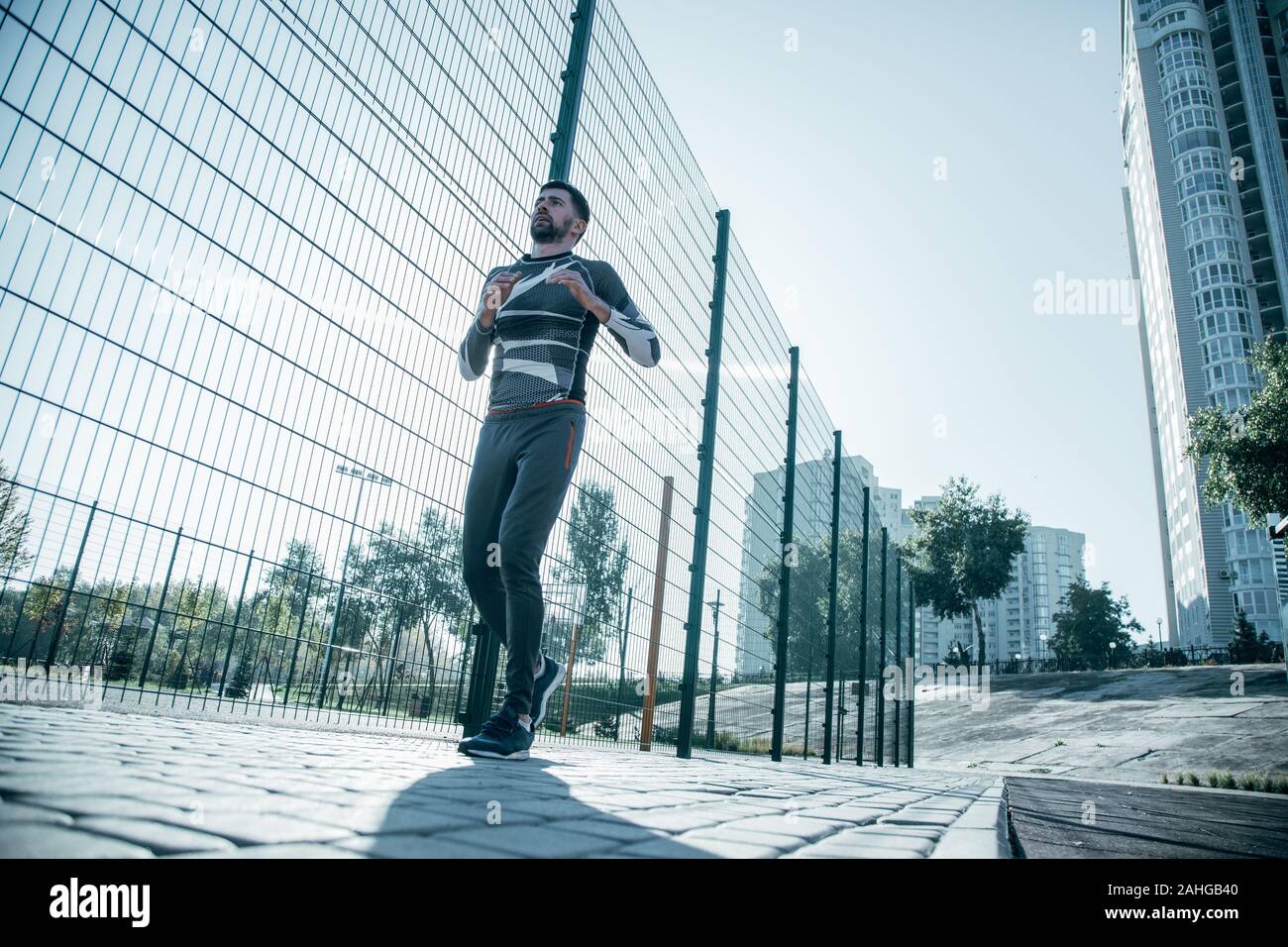 Serious sportsman running while having his training outdoors Stock ...