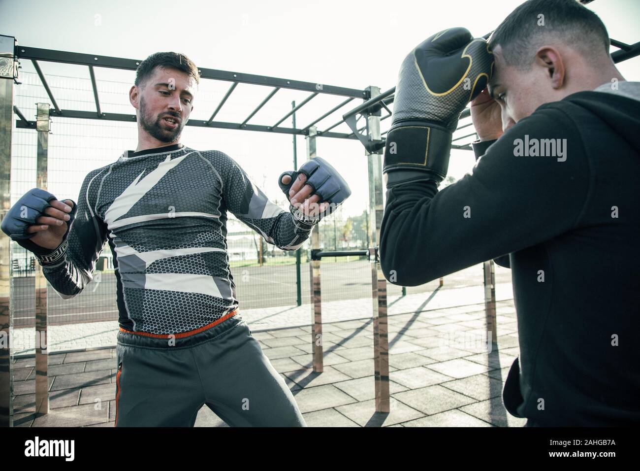 Serious boxer looking tired while training with partner Stock Photo - Alamy