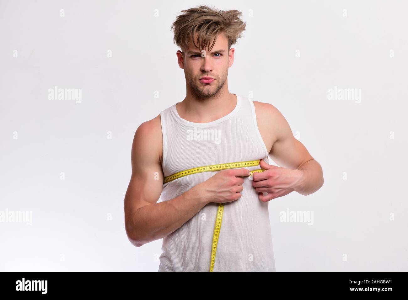 Man with long yellow measuring tape. Measurement and size concept. Guy ...