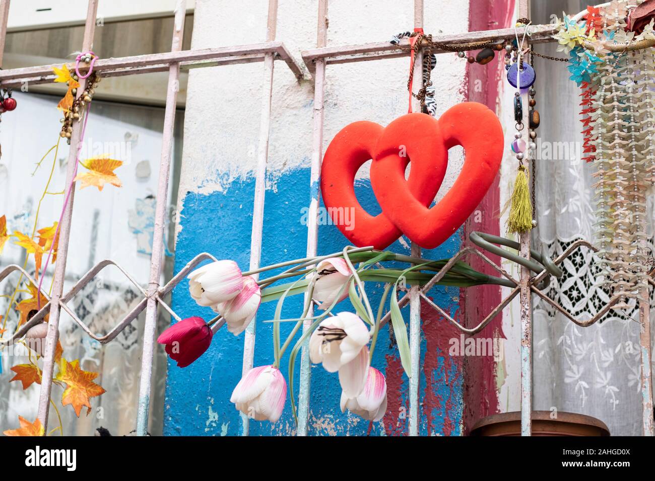 Iron bars of the old house. It has ornaments with red hearts and fake ...