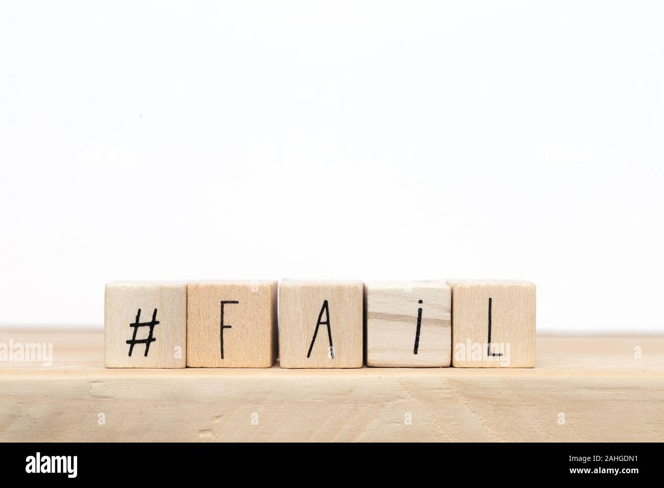 wooden cubes with a hashtag and the word fail near white background ...