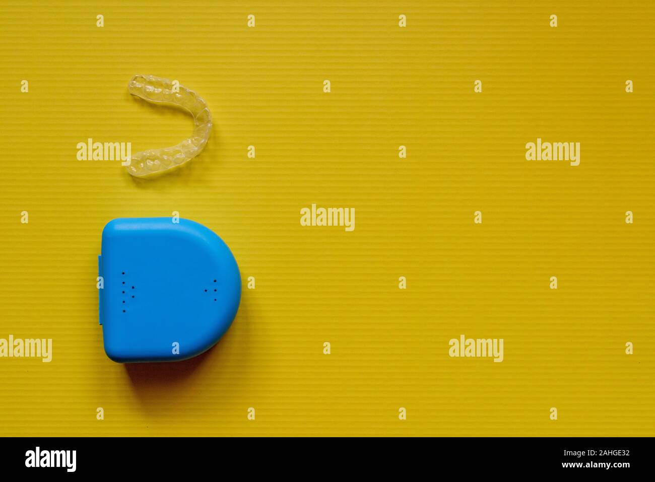 Dental retainer and its box on a yellow background. Health Concept ...