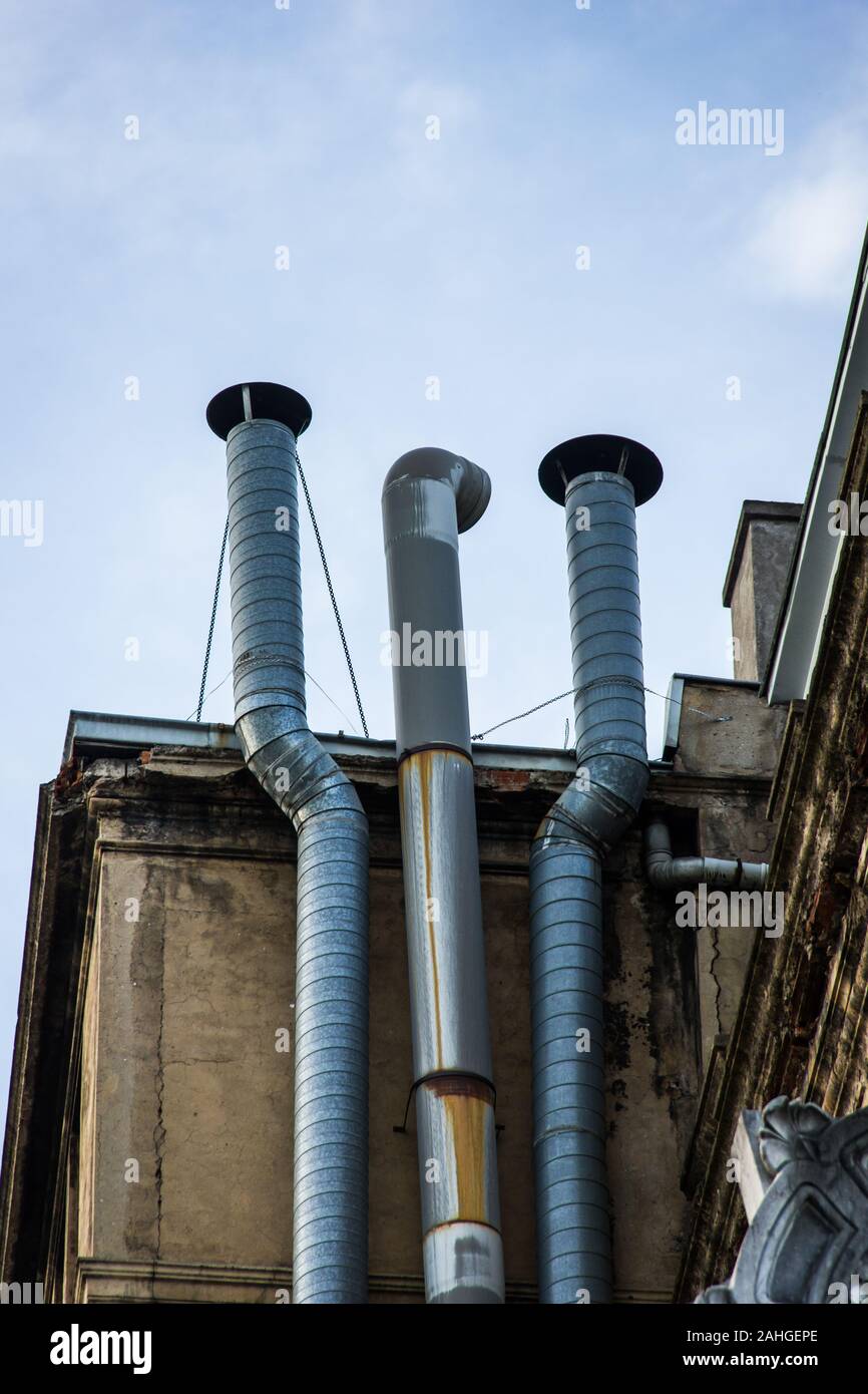 Metal chimneys standing above building roof of industrial building ...