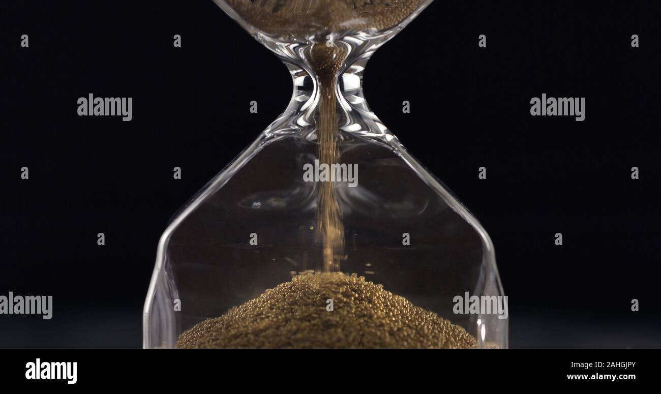 Sand moves through hourglass. Close up of hour glass clock. Old time ...