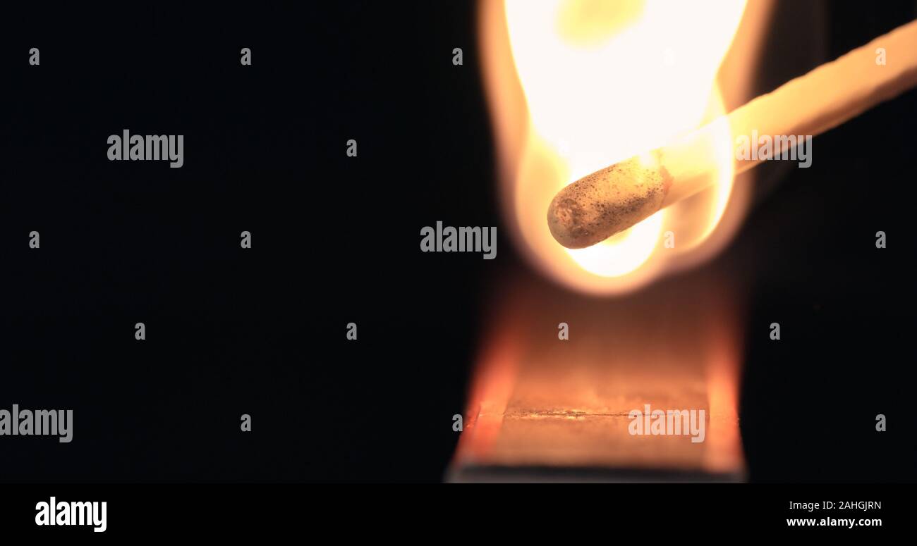 Firing up matches. Ignition lose-up detail of on matchbox and showing ...