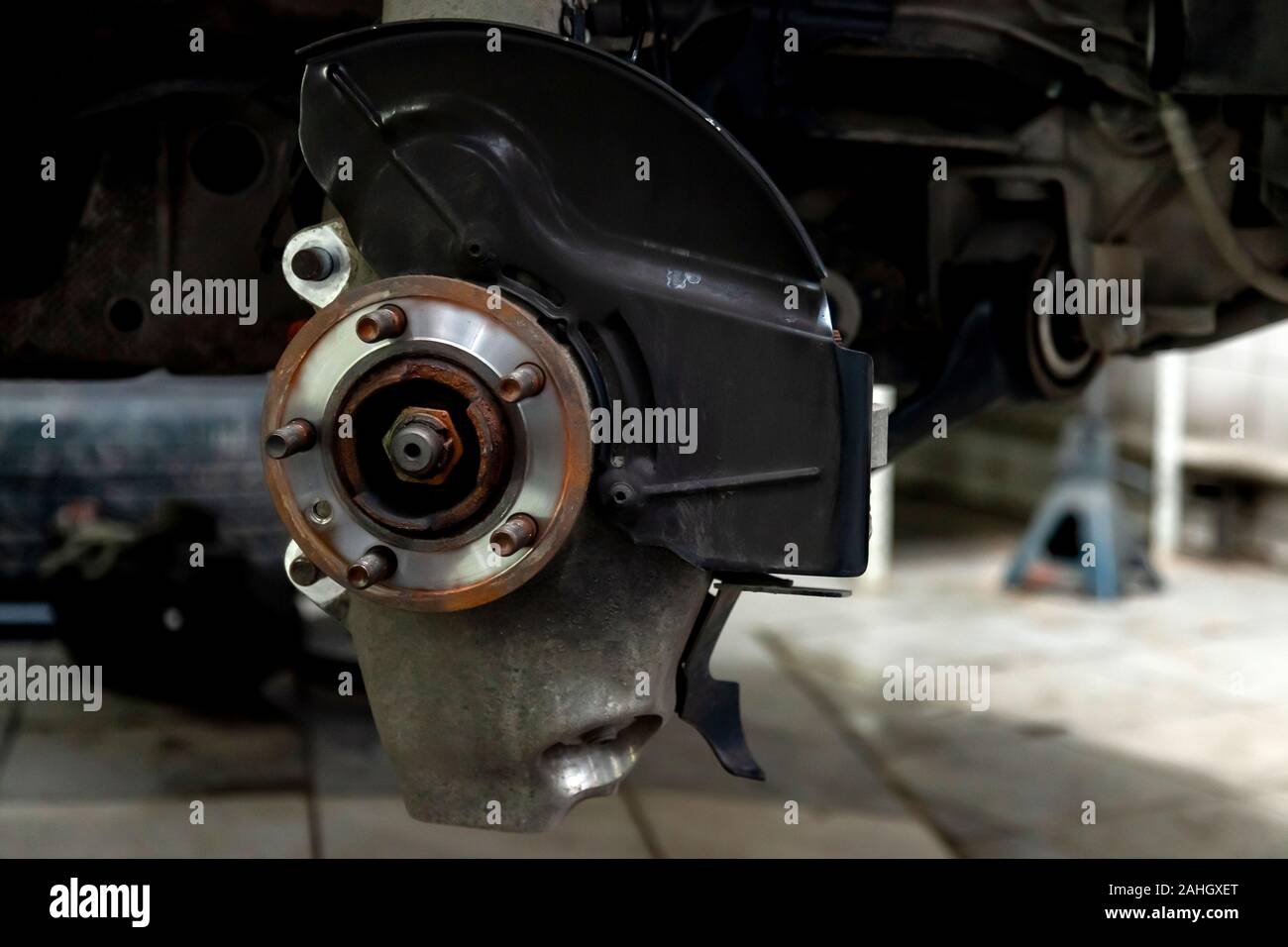A close-up on the front brake system of a car with hub on a lift in a ...