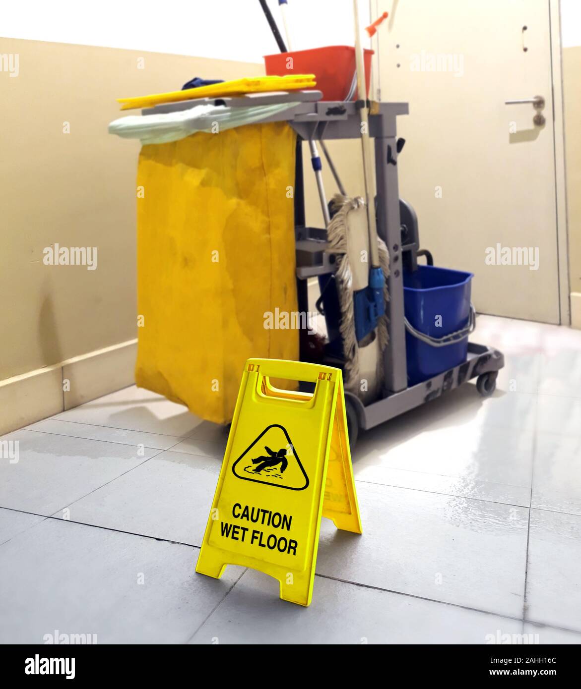 wet floor signage with cleaning tools in background Stock Photo - Alamy