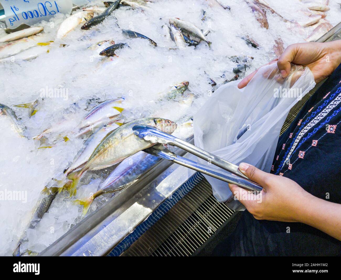 Woman hand picking fish at seafood stall in the supermarket Stock Photo ...