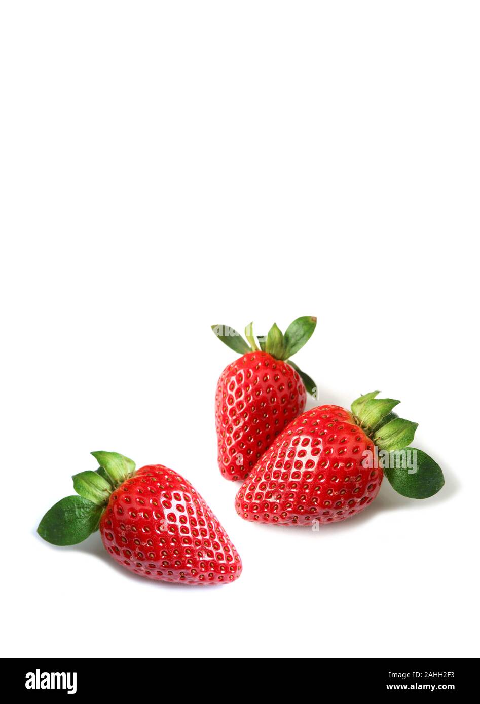 Vibrant red fresh strawberries scattered on white background with copy ...